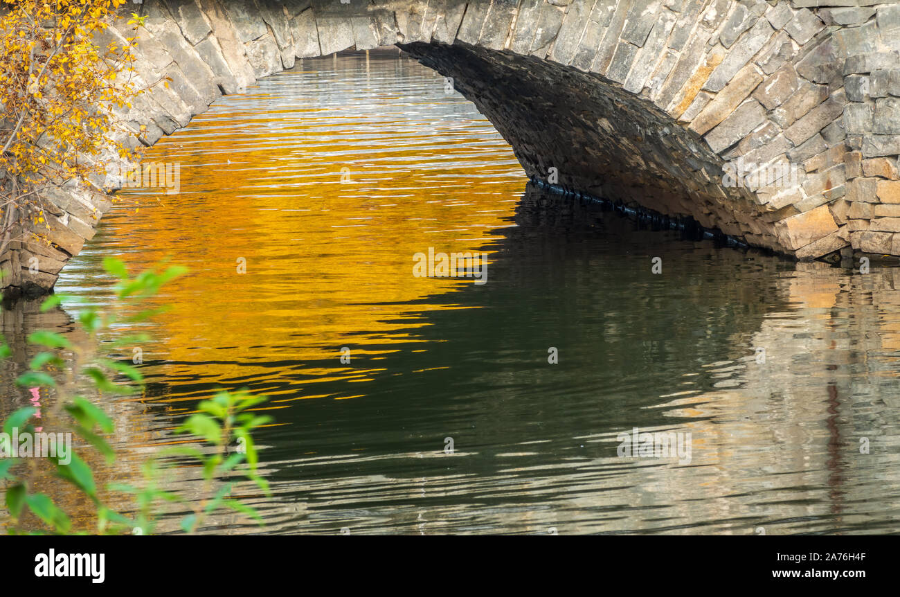 Stonework of a bridge pylon with reflection in the water. Old stone ...