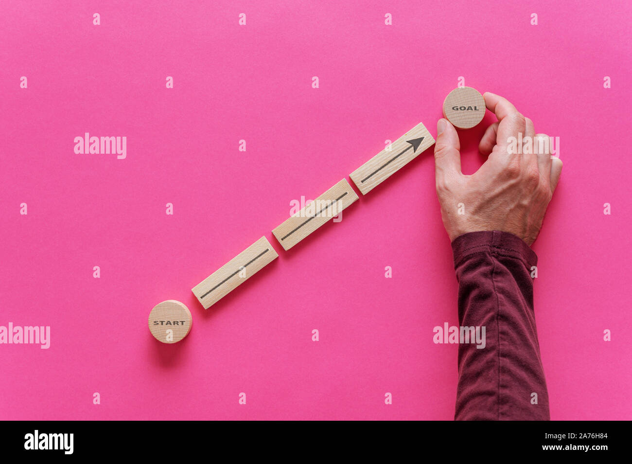 Male hand placing wooden pegs and circles to form a diagram with arrow ...