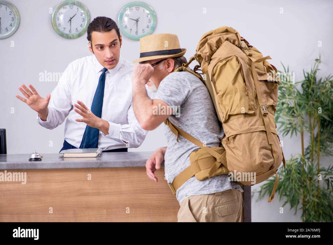 Old backpacker at the hotel reception Stock Photo - Alamy