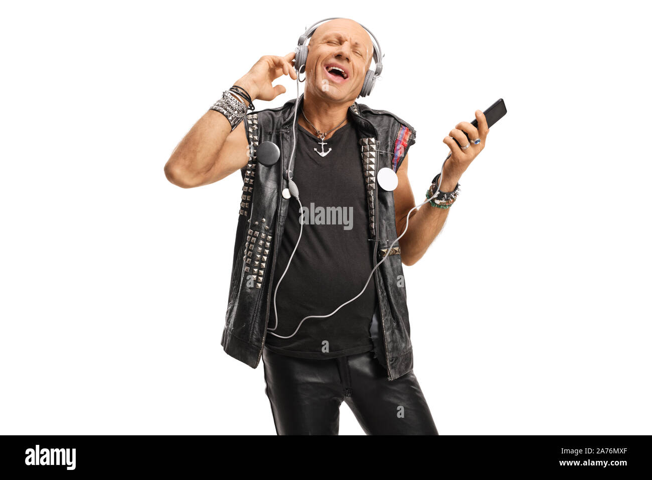 Punk listening to music on headphones plugged into a mobile phone ...