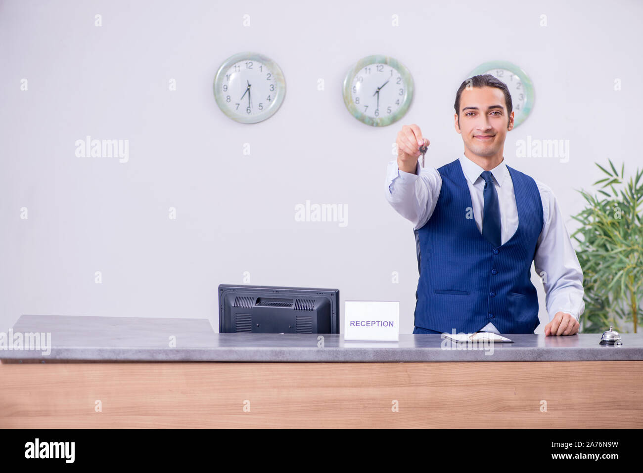The young man receptionist at the hotel counter Stock Photo - Alamy