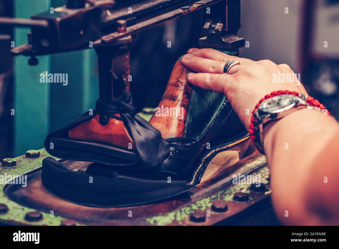 Hands of an experienced cobbler in the handmade footwear industry, is ...