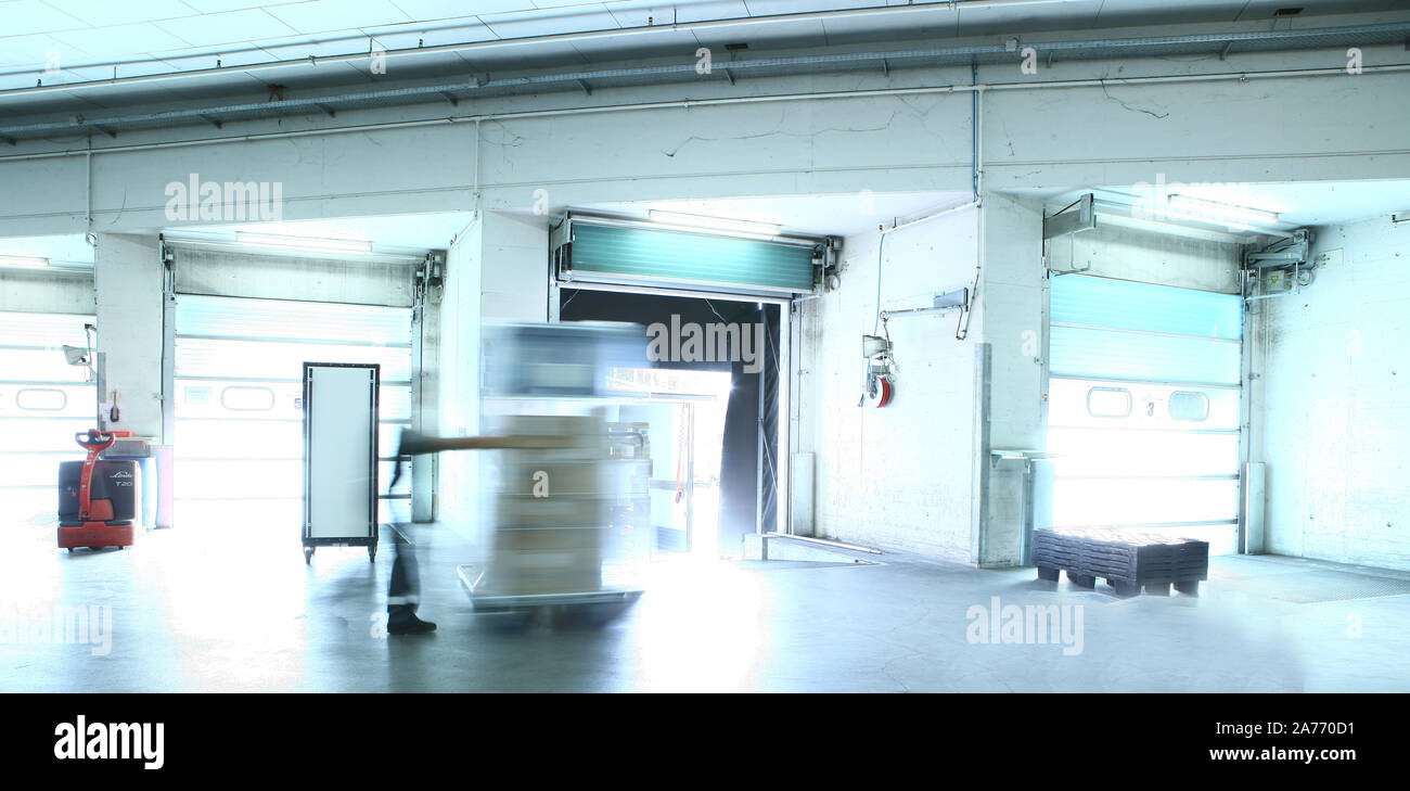 Workers in a warehouse loading up a car Stock Photo - Alamy