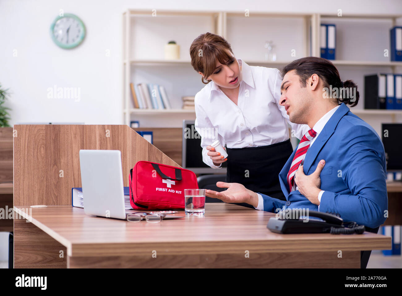 Employee receiving first aid in office Stock Photo - Alamy