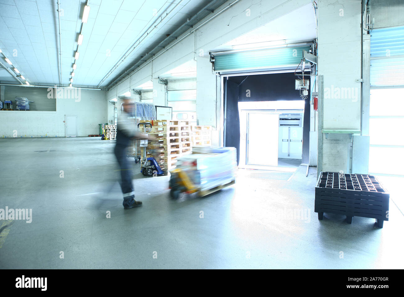 Workers in a warehouse loading up a car Stock Photo - Alamy