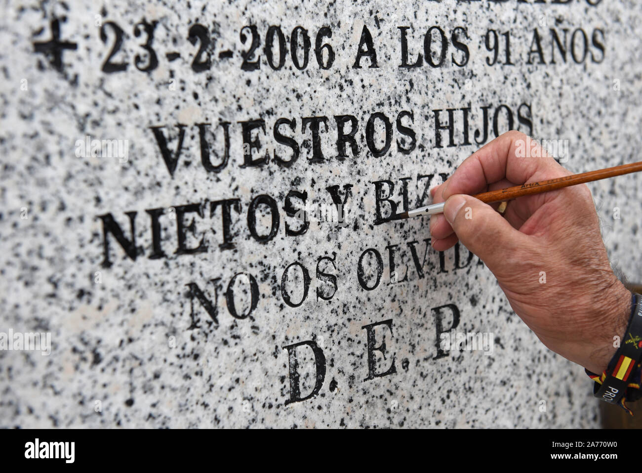 A man paints the inscription on a gravestone at Sur cemetery in Madrid ...