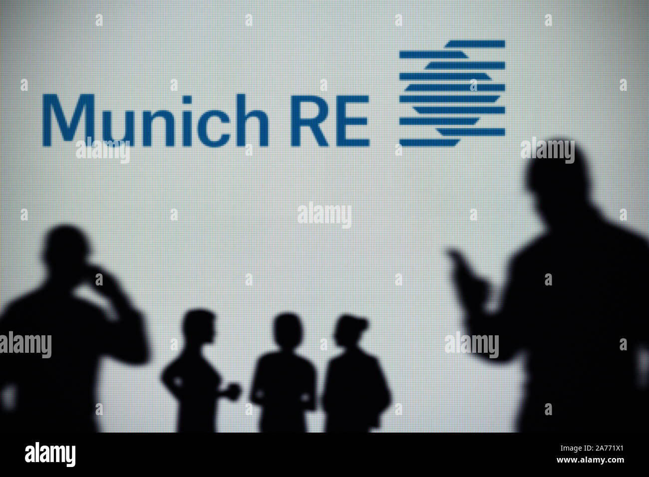 The Munich RE logo is seen on an LED screen in the background while a ...