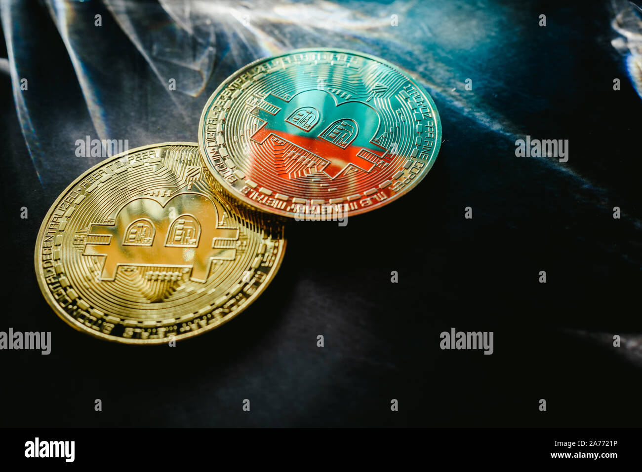 Bitcoin physical coins illuminated by light rays with dark background ...