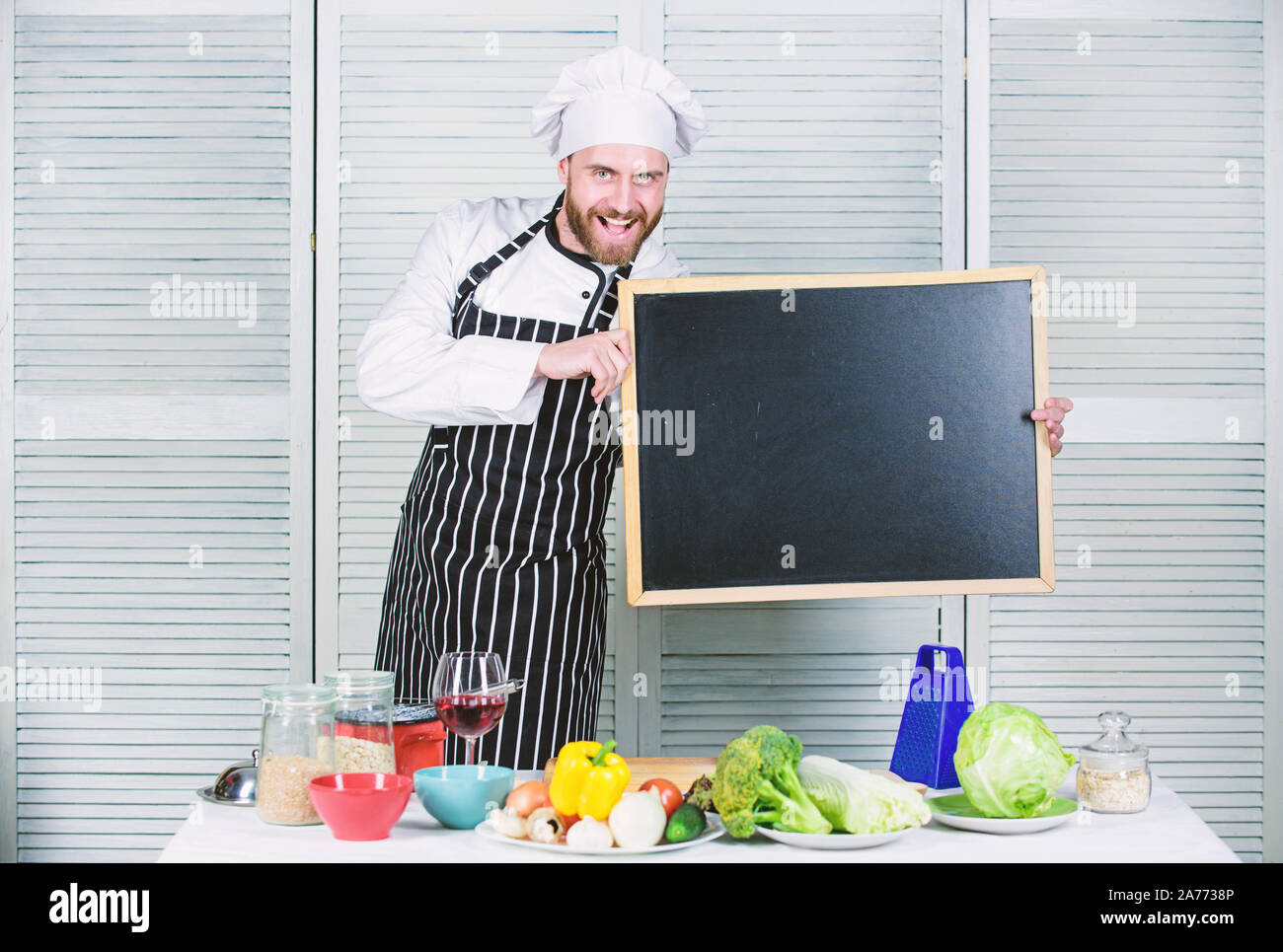 Learning to cook vegetables. Man holding empty blackboard. Chief cook ...