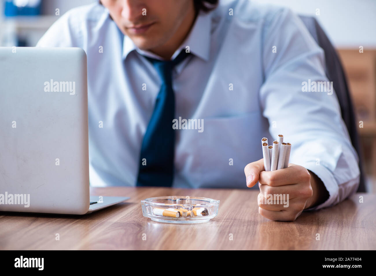 The male employee smoking cigarettes at workplace Stock Photo - Alamy
