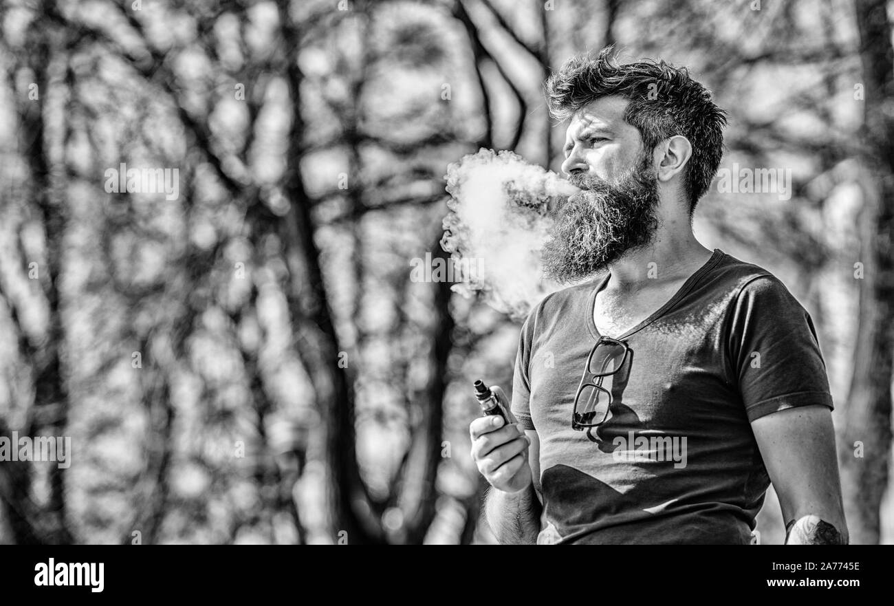 Stress relief concept. Bearded man smoking vape. White clouds of ...