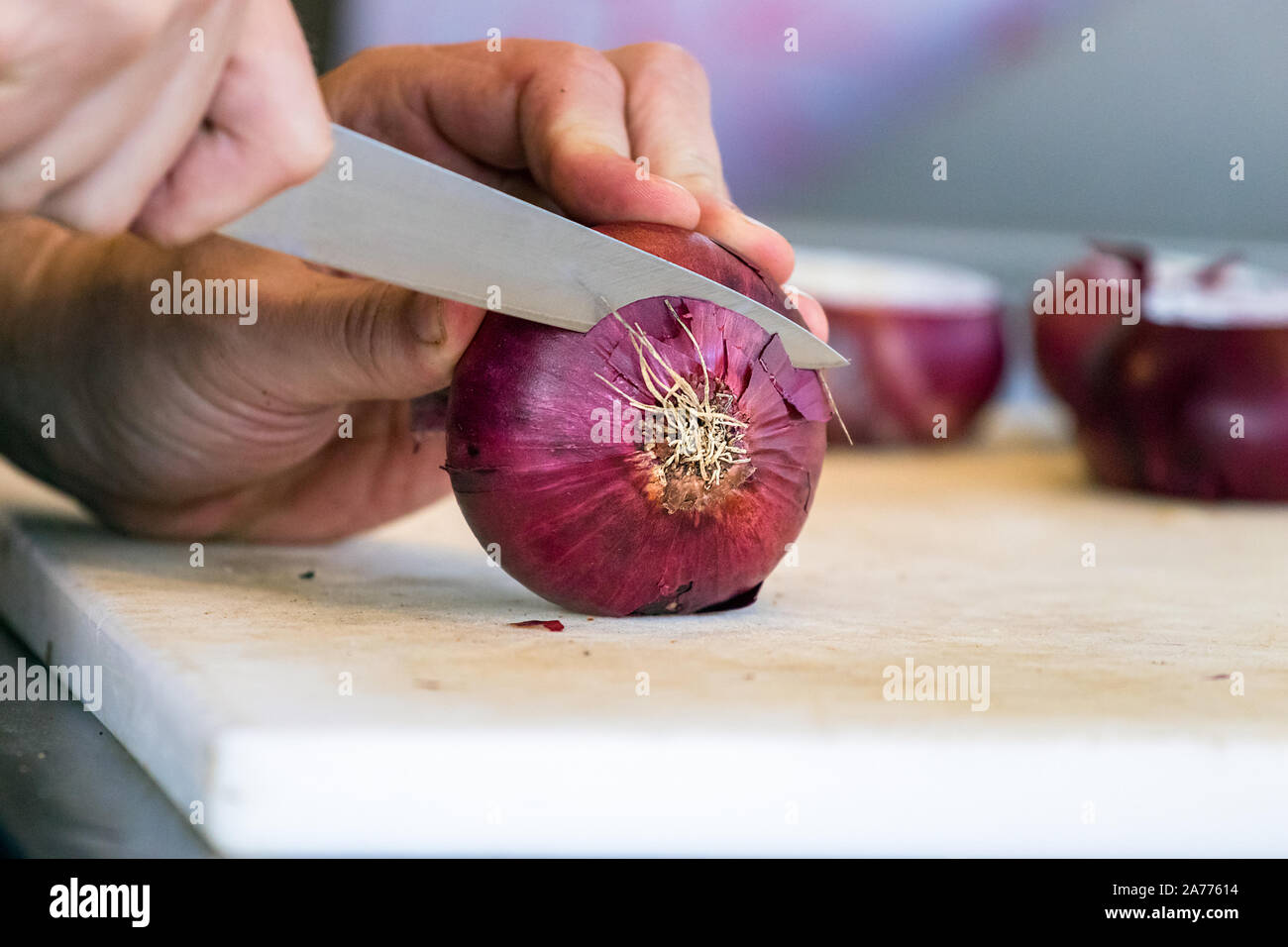 Male hand cutting - chopping red onions, sun light Stock Photo - Alamy