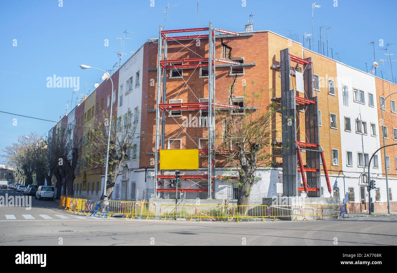 Reinforced building with structural bracing on facade. Visible crack ...