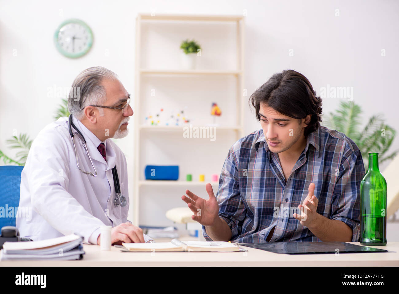 The young male alcoholic visiting old doctor Stock Photo - Alamy