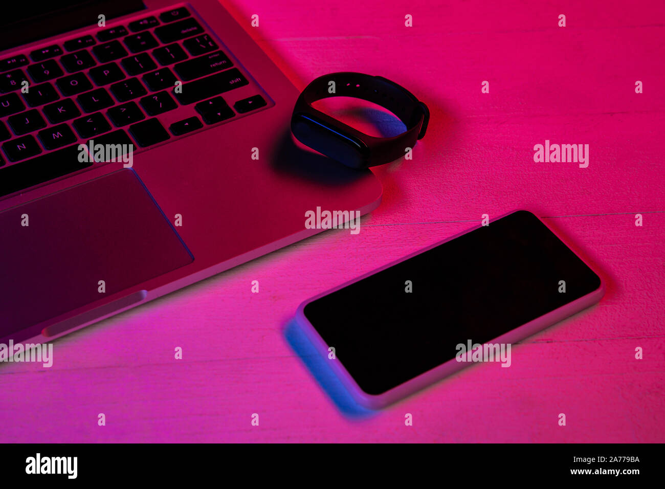 Top view of set of gadgets in purple neon light and pink background ...