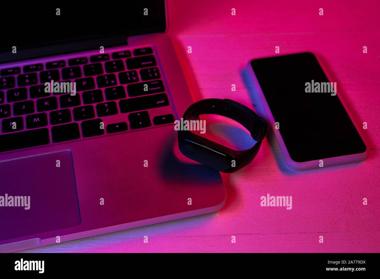 Top view of set of gadgets in purple neon light and pink background ...