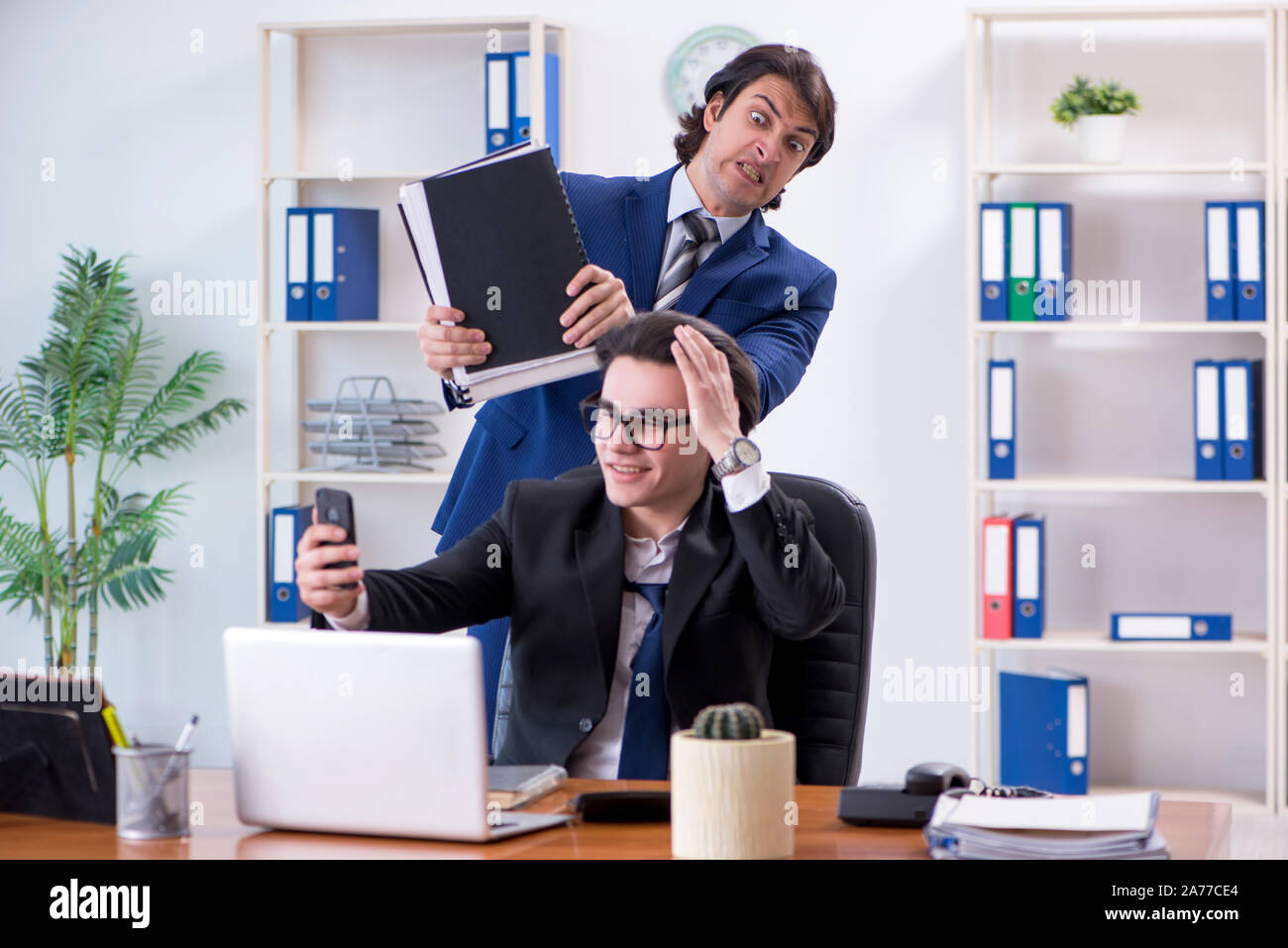 The boss and his male assistant working in the office Stock Photo - Alamy