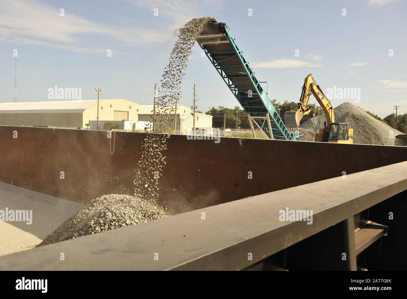 A Unified Command response crew uses a hopper-belt-conveyor to load ...