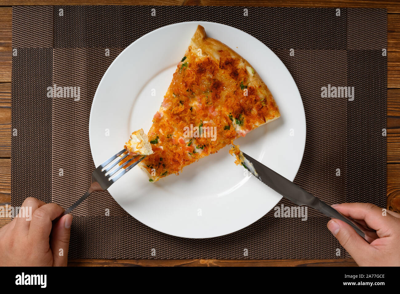 top view man eating piece of pizza with shredded pork and barbeque pork ...