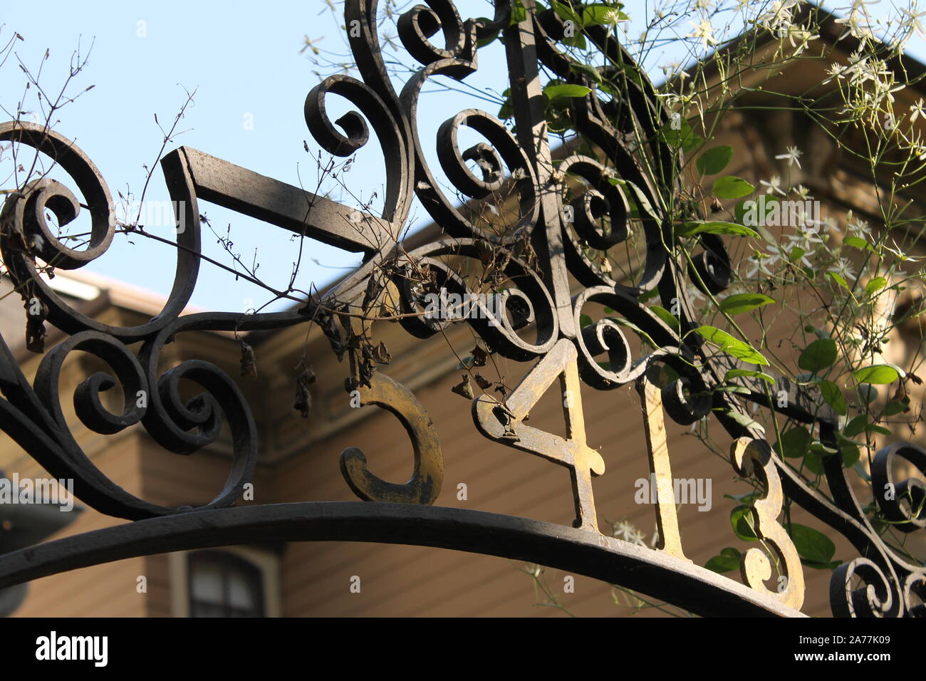 A gothic gate with an address for a house Stock Photo - Alamy