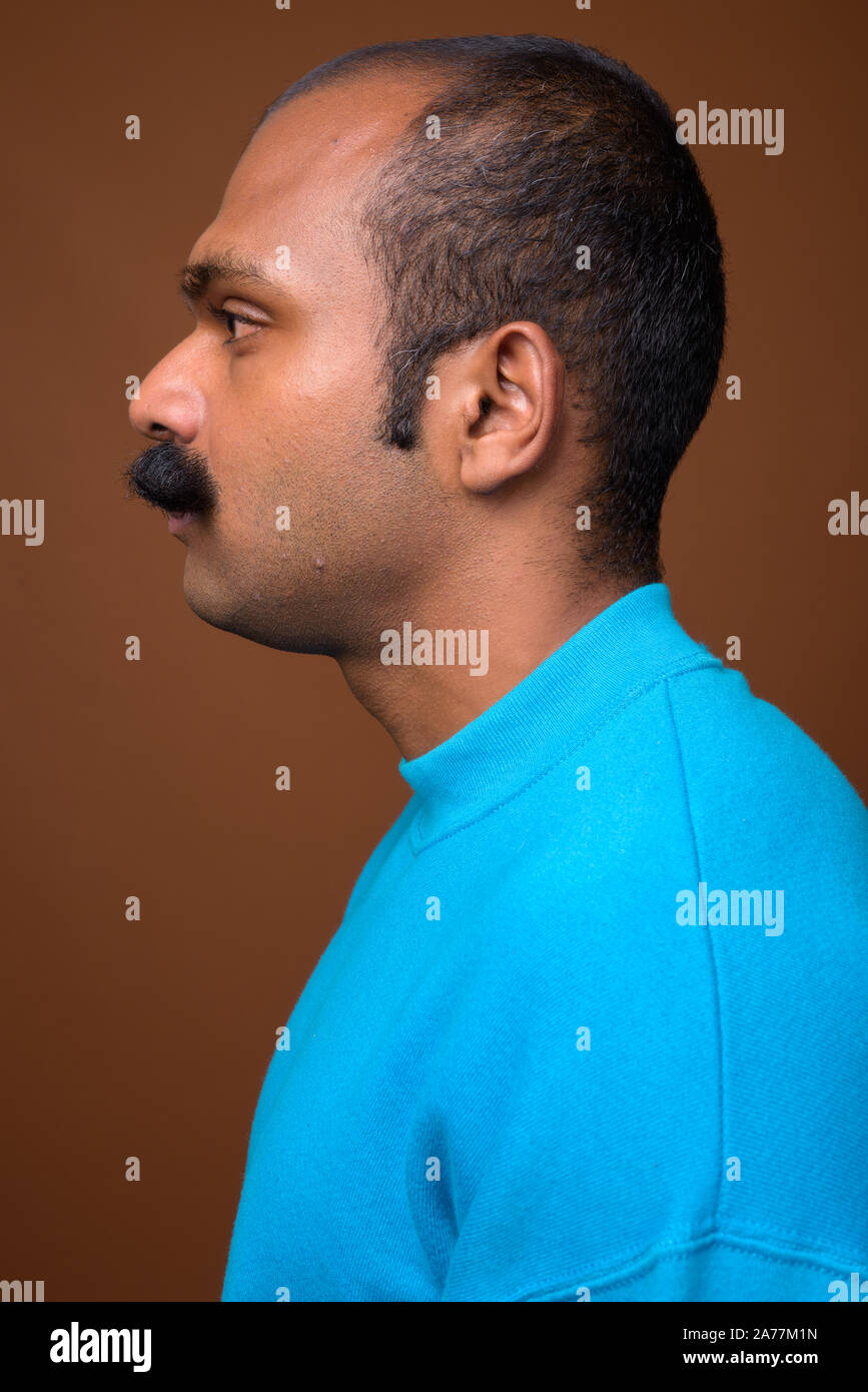 Closeup profile view of Indian man with mustache wearing blue sweater ...