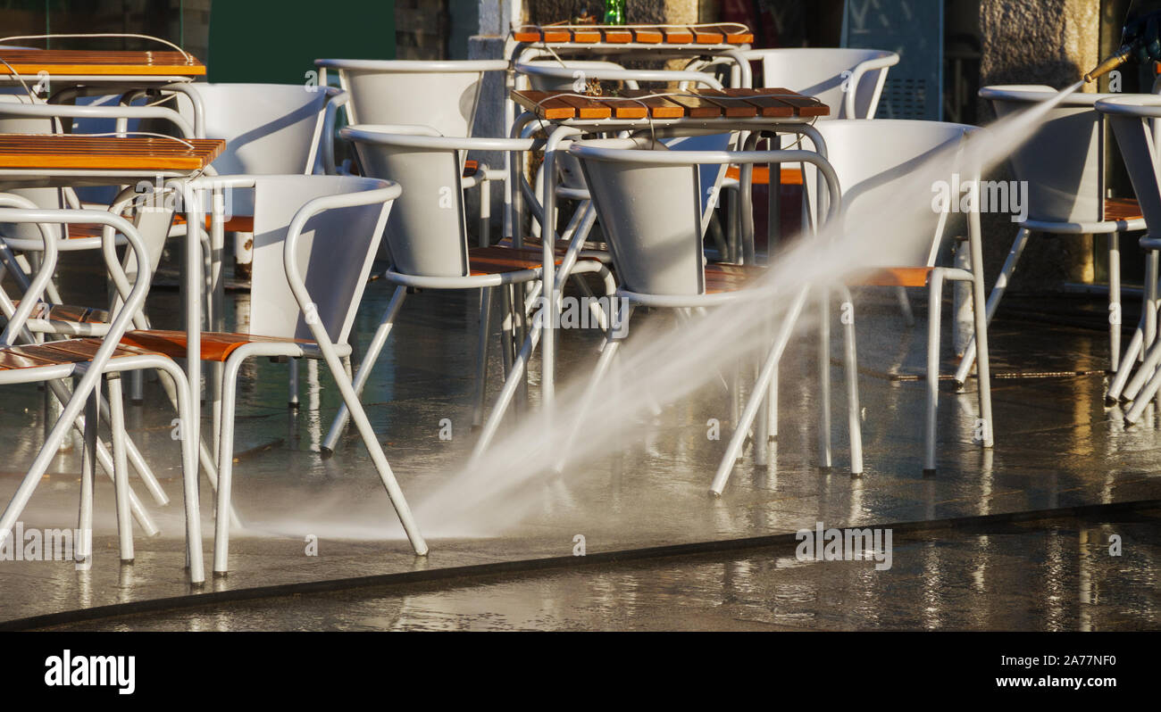 Wet cleaning floor of street cafe with pressurized water Stock Photo ...