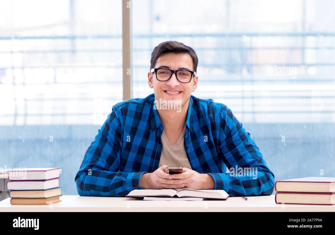 Student studying in the empty library with book preparing for exam ...