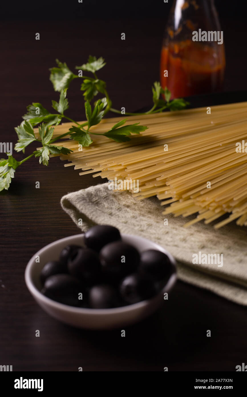 Dried spaghetti before cooking on the kitchen table Stock Photo - Alamy