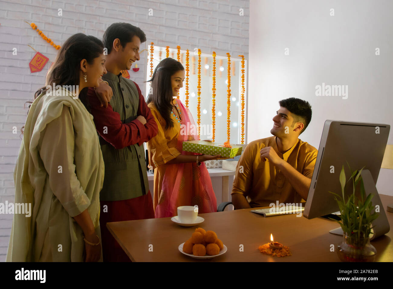 Colleagues giving gift to each other in office on the occasion of ...
