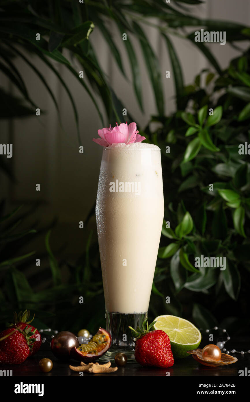 milkshake in a tall glass decorated with a flower on a background of ...