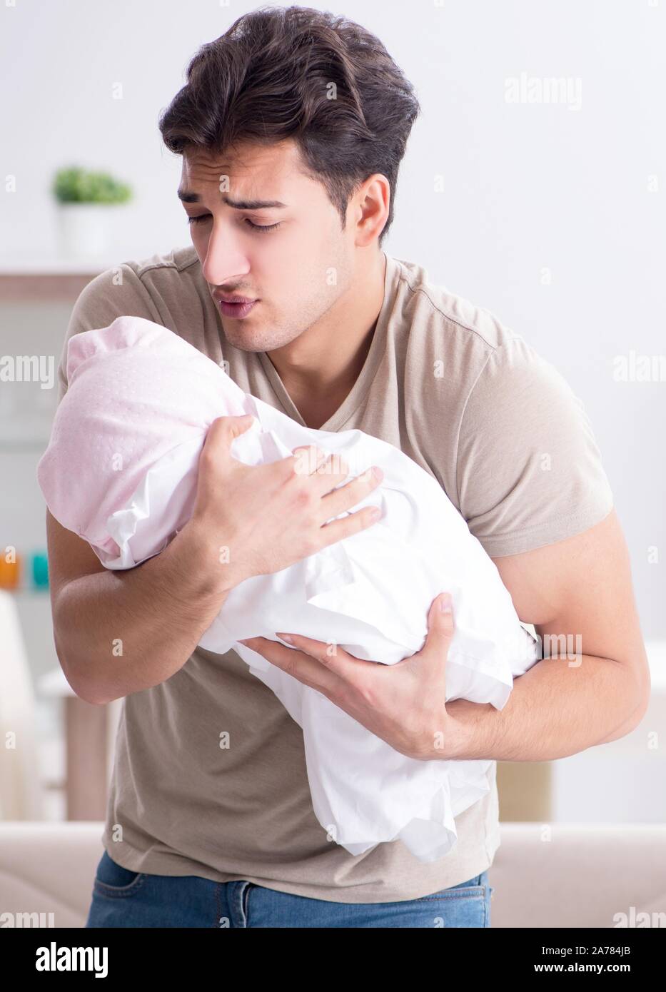 The young father dad frustrated at crying baby Stock Photo - Alamy