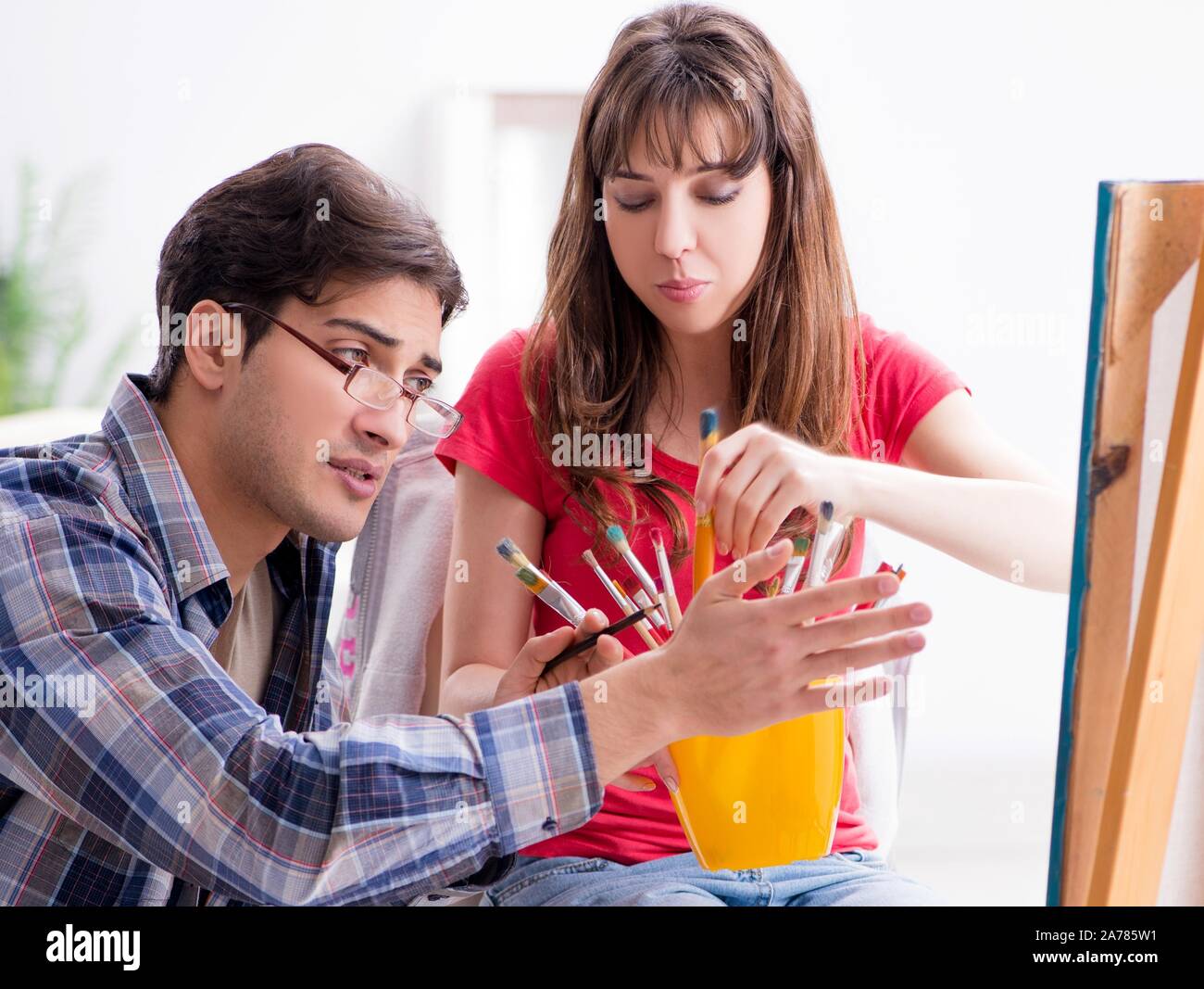 The artist coaching student in painting class in studio Stock Photo - Alamy