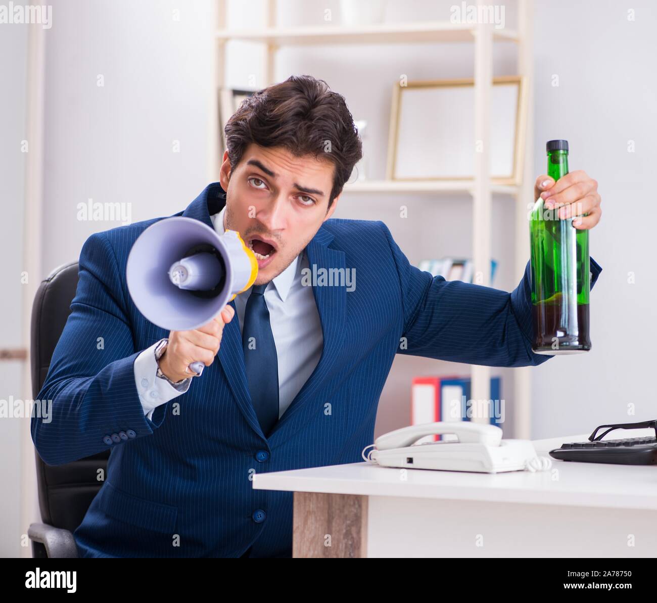 The young businessman employee drinking in the office at desk Stock ...