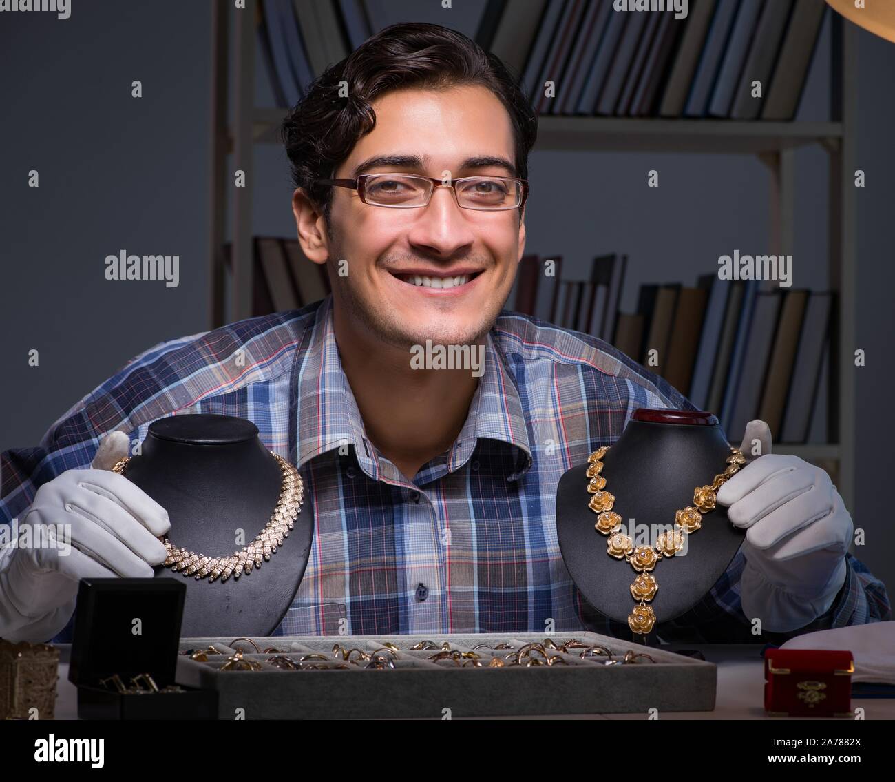 Young male jeweller working at night in his workshop Stock Photo - Alamy