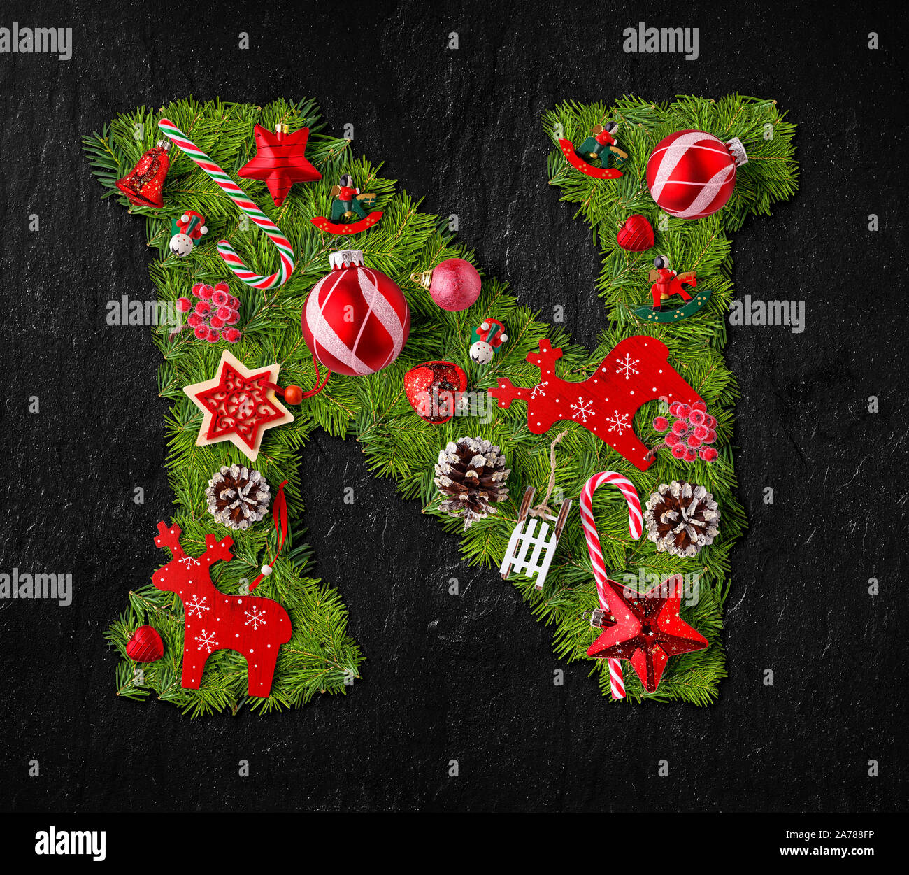 Letter N made of Christmas tree ornaments on a black slate background ...