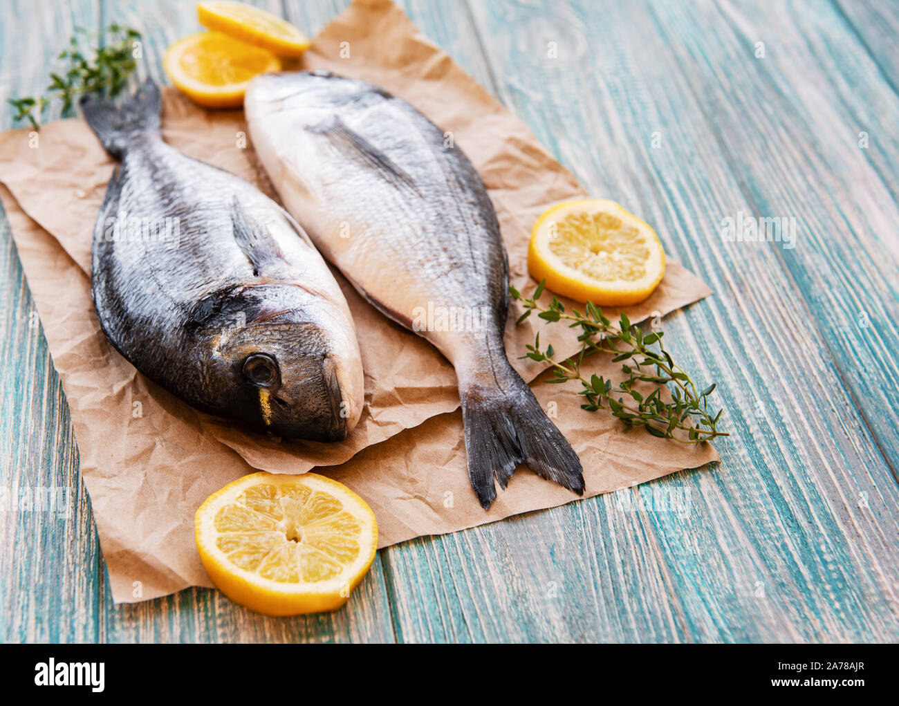 Fresh fish dorado. Dorado and ingredients for cooking on a table Stock ...