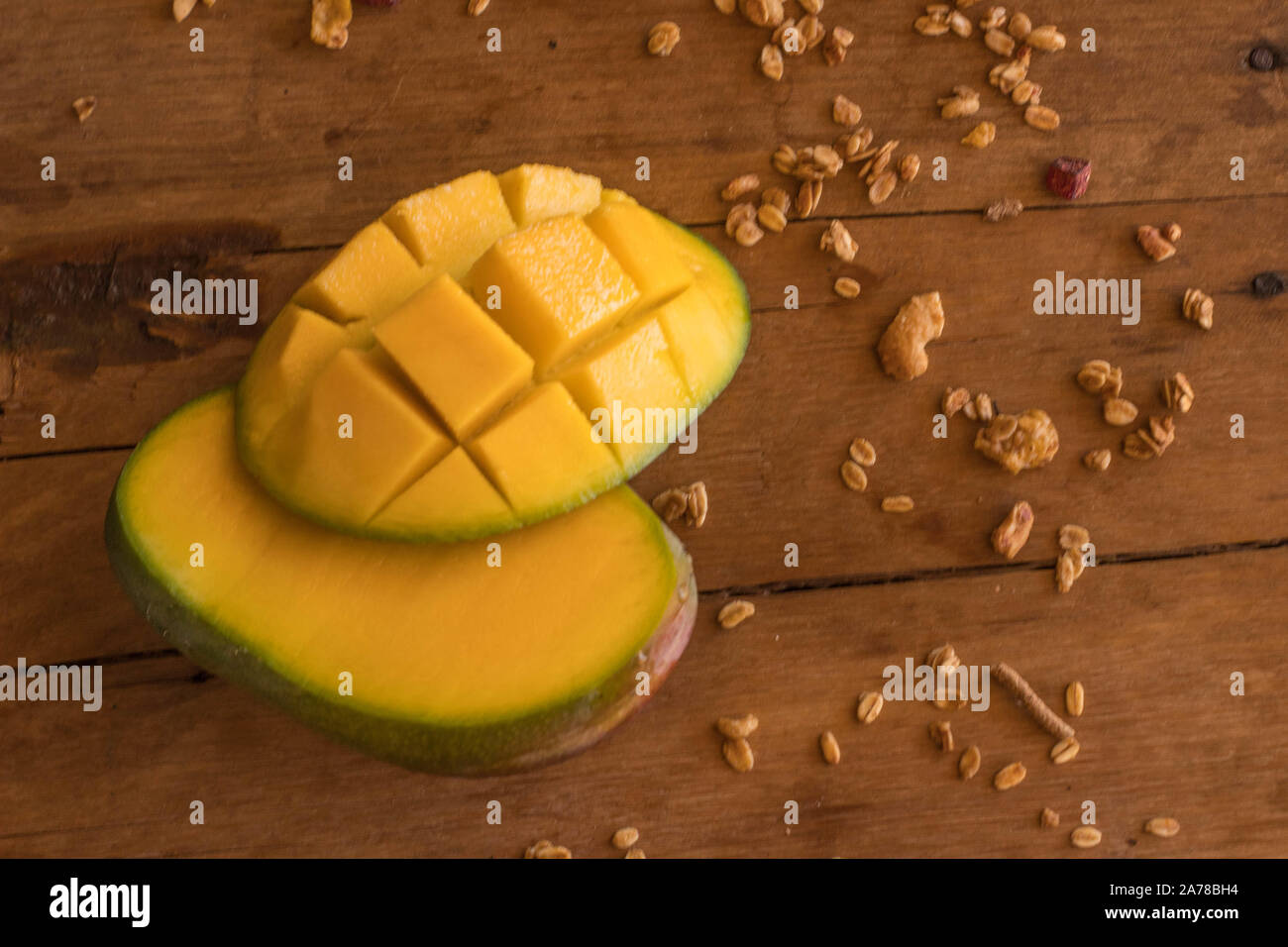 traditional brazilian fruit, mango on wooden table with granolas with ...