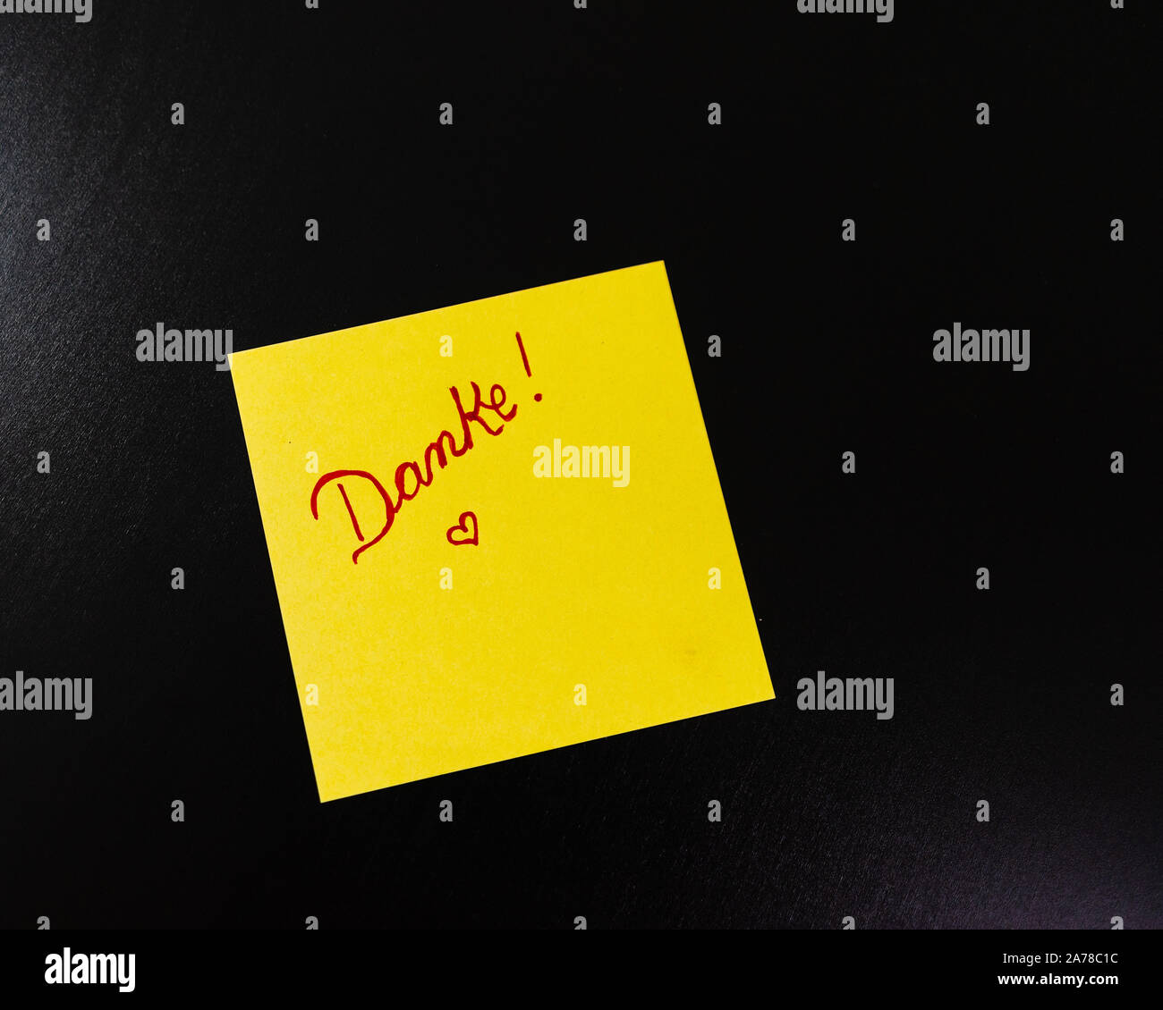 Text Danke on sticky note. Yellow sticky note on black background Stock ...