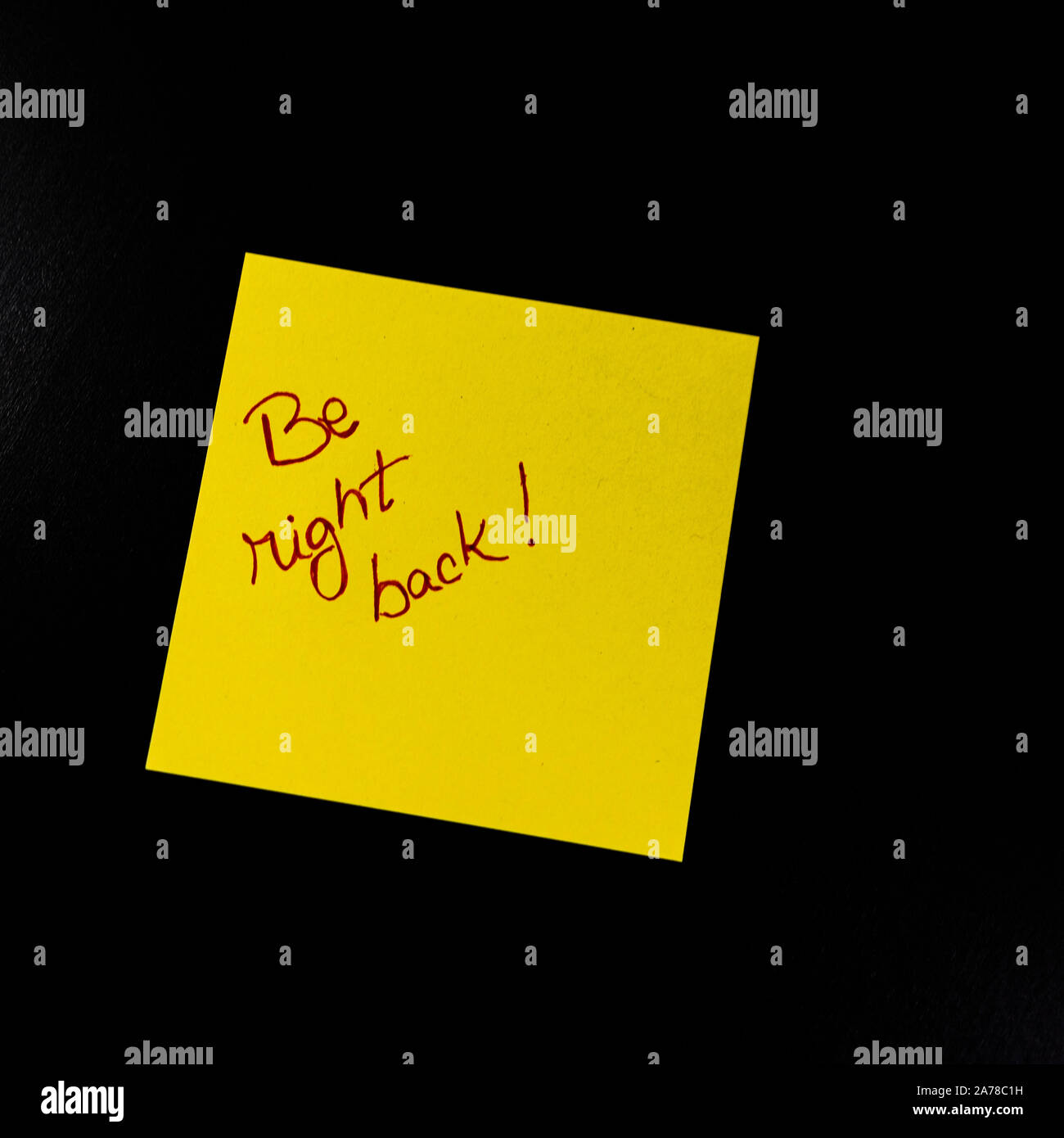 Text Be right back on sticky note. Yellow sticky note on black ...