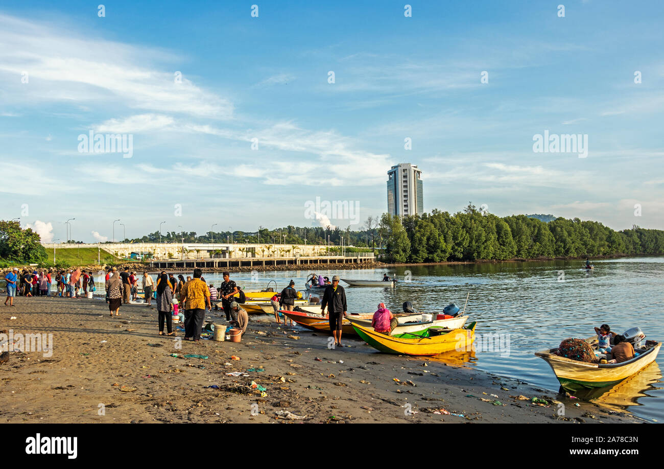 Crowds of local people waiting for the fishing catch to come in so they ...