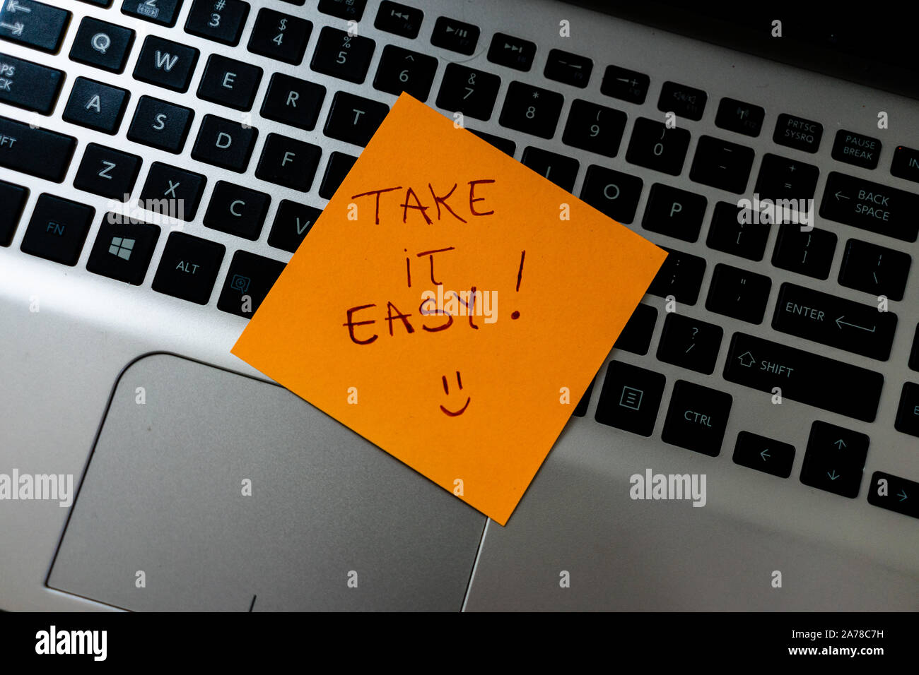 Text Take it easy on sticky note. Orange sticky note on keyboard Stock ...
