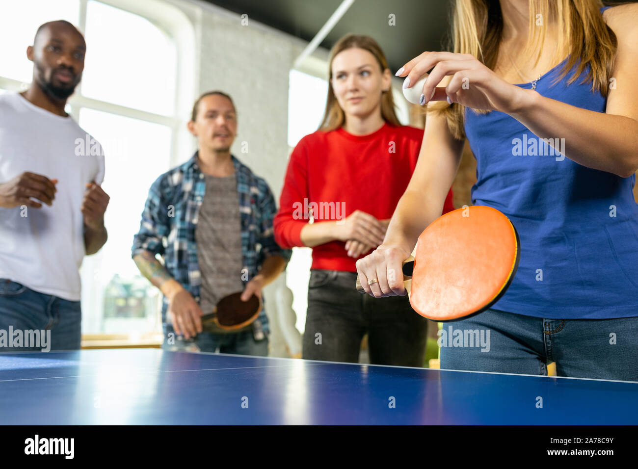 Young people playing table tennis in workplace, having fun. Friends in ...