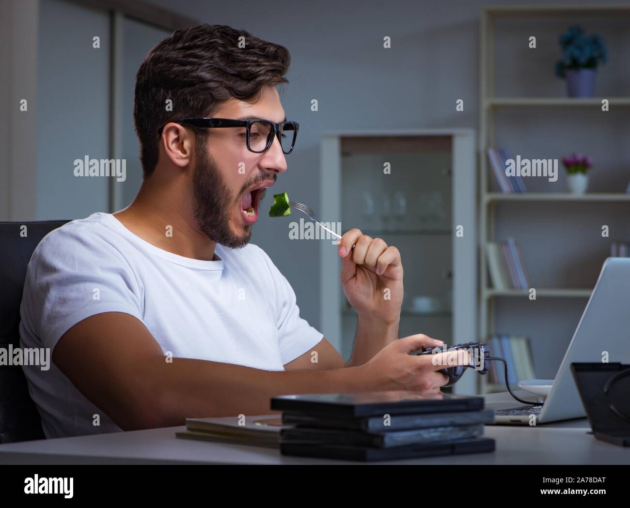 The young man playing games long hours late in the office Stock Photo ...