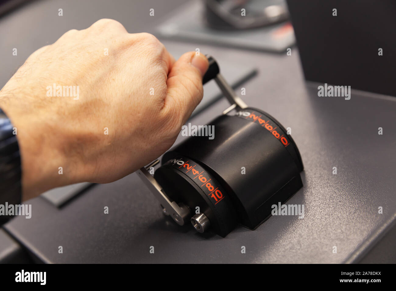 Male hand moves an engine accelerator on modern ship control panel ...