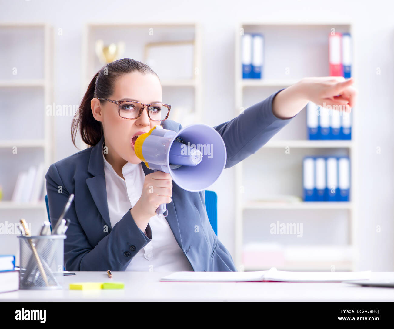 The angry businesswoman yelling with loudspeaker in office Stock Photo ...