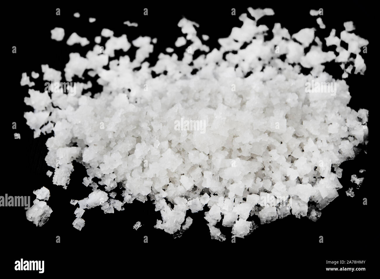 Salt grains on black background Stock Photo - Alamy