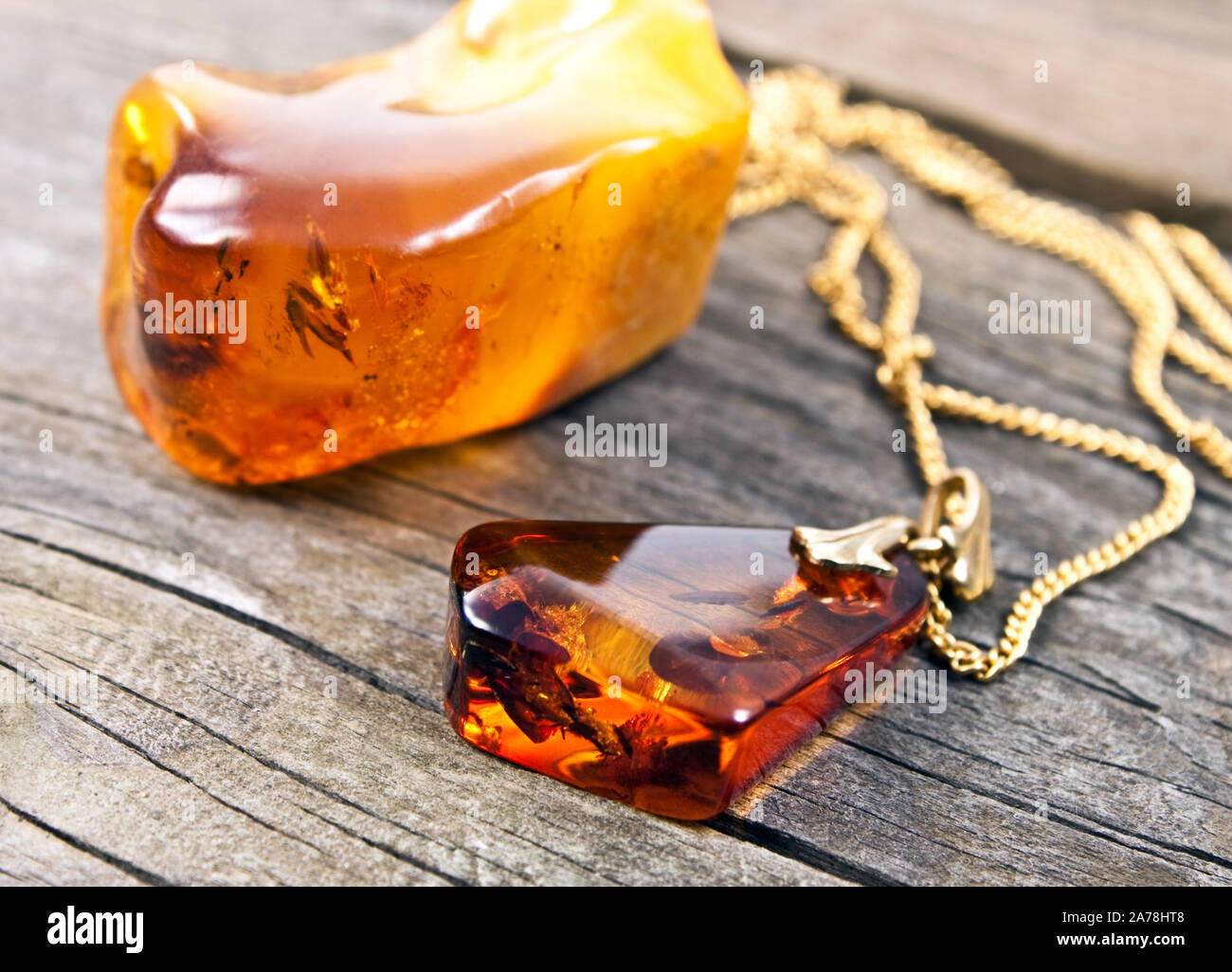 Amber with chain against wooden background Stock Photo - Alamy
