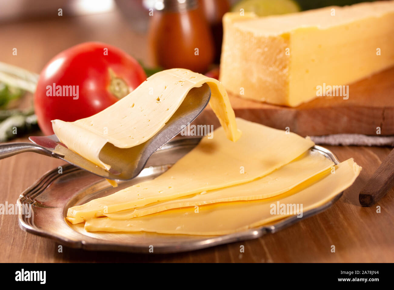 The process of slicing fresh cheese slicer Stock Photo - Alamy