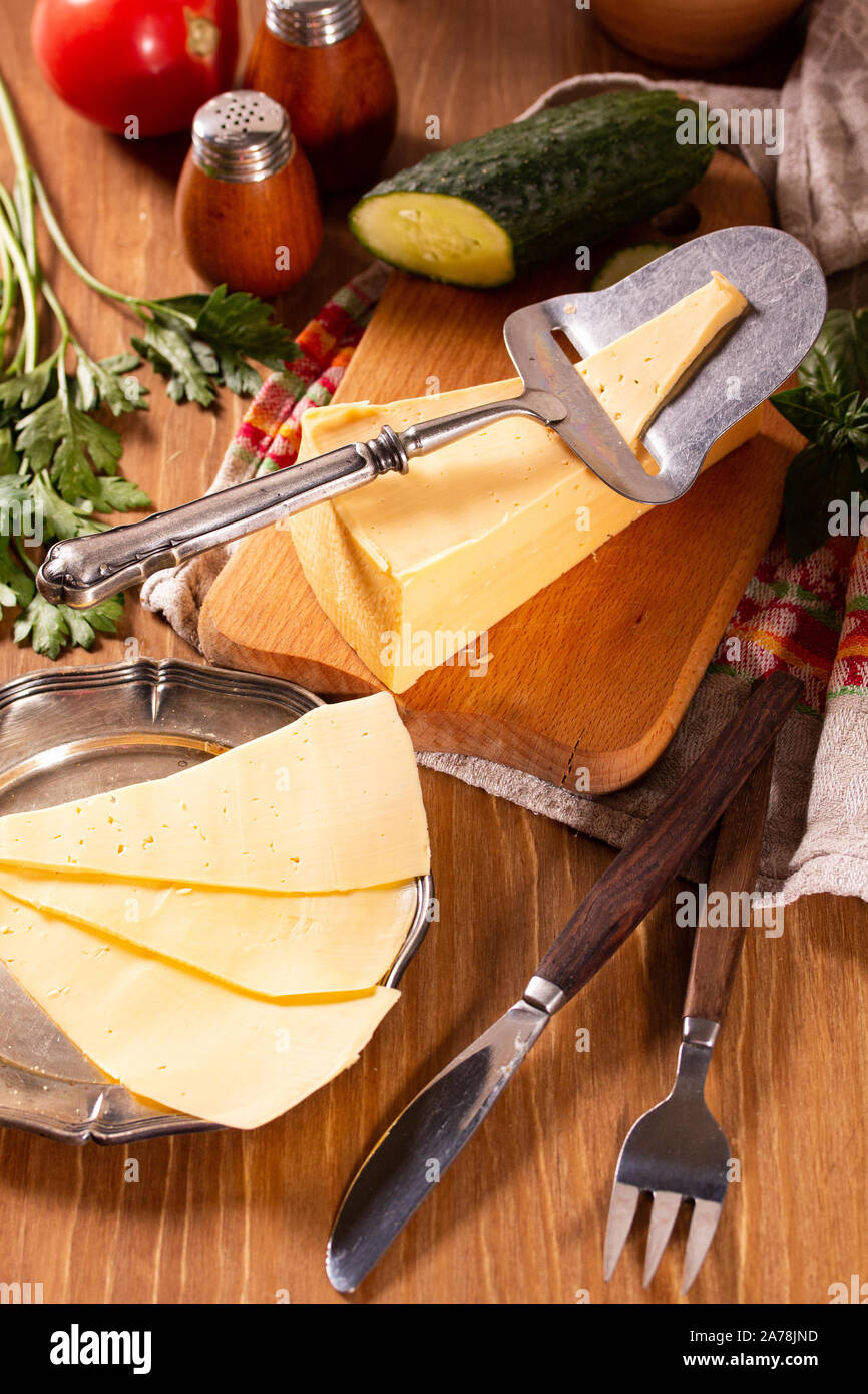 The process of slicing fresh cheese slicer Stock Photo - Alamy