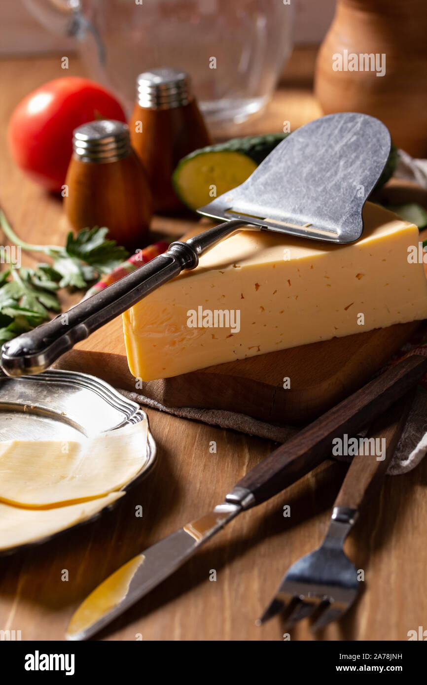 The process of slicing fresh cheese slicer Stock Photo - Alamy